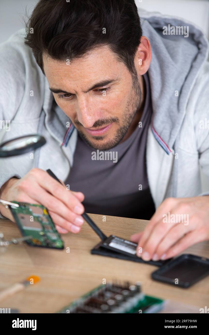 man is repairing broken pc with a screw driver Stock Photo - Alamy
