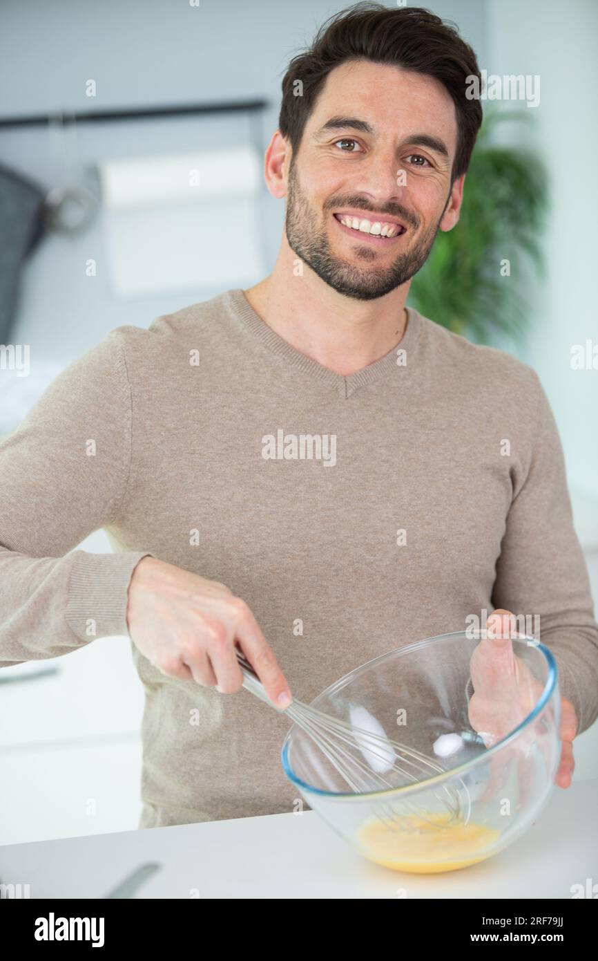 man blending eggs with special equipment in glass bowl Stock Photo - Alamy