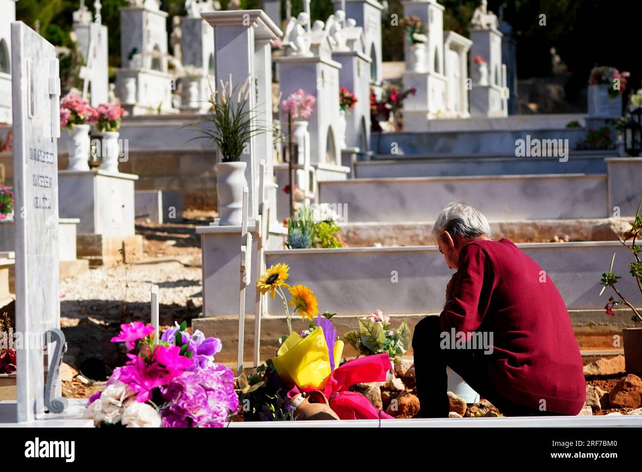 David Hunter lays flowers at the grave of his wife Janice Hunter at a ...