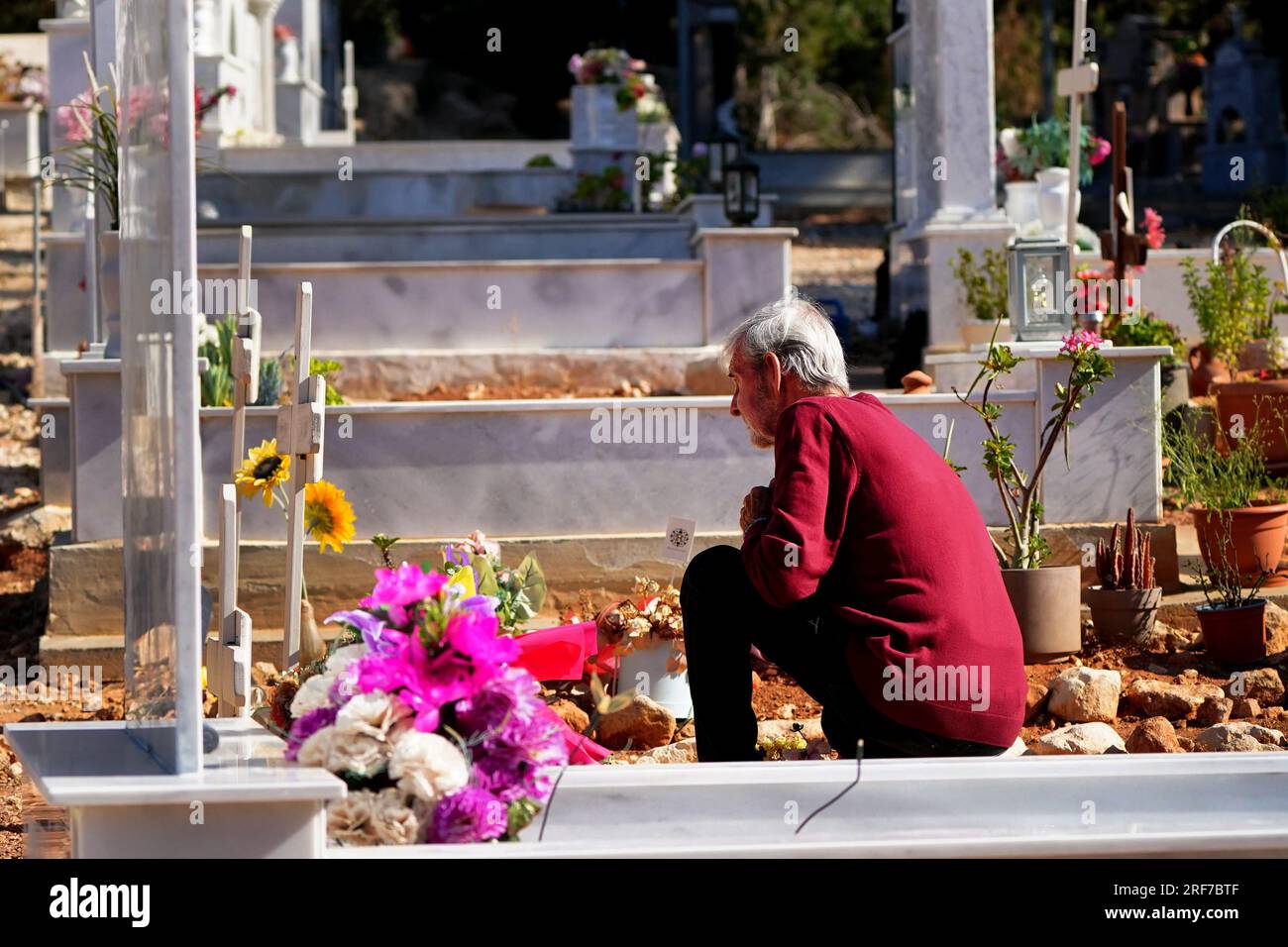 David Hunter lays flowers at the grave of his wife Janice Hunter at a ...