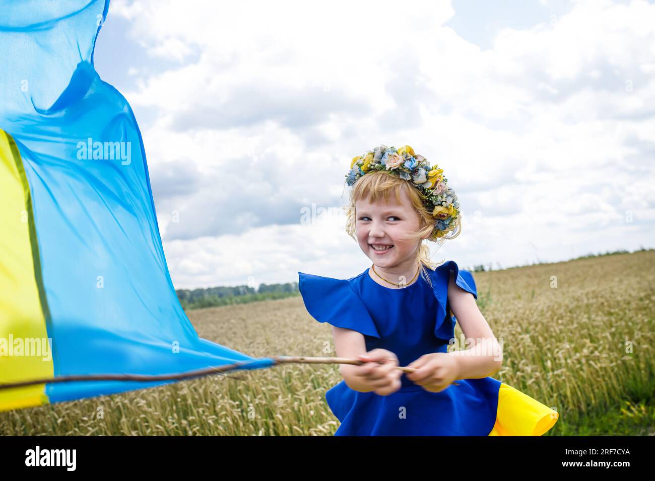 flag of Ukraine is on the shoulders of a little Ukrainian girl. Happy ...
