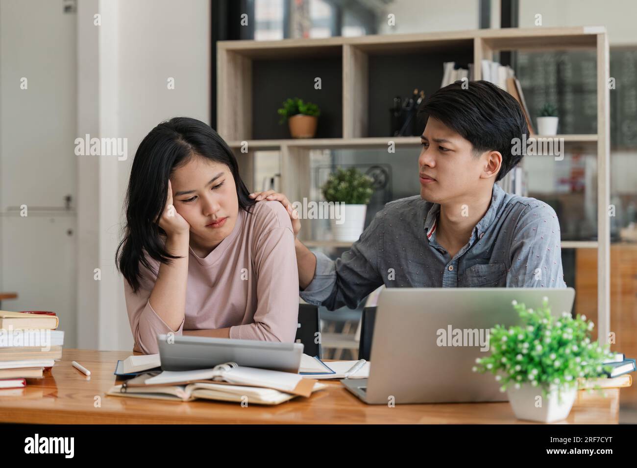 Caring Asian male students is comforting female students and showing ...