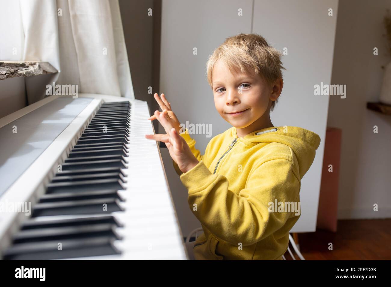 Blond boy playing piano hi-res stock photography and images - Alamy