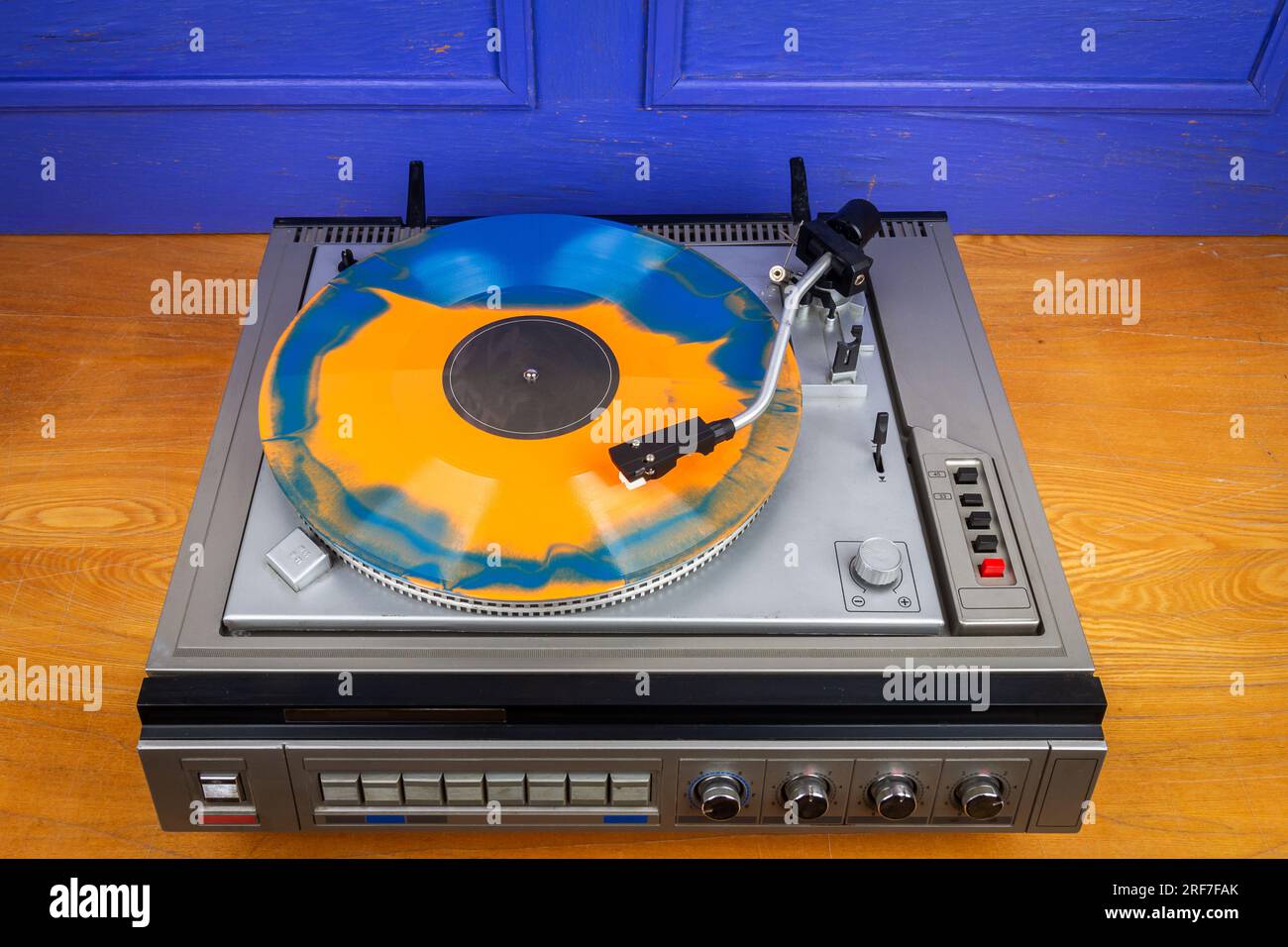 Vintage turntable vinyl record player with blue and orange vinyl on a ...