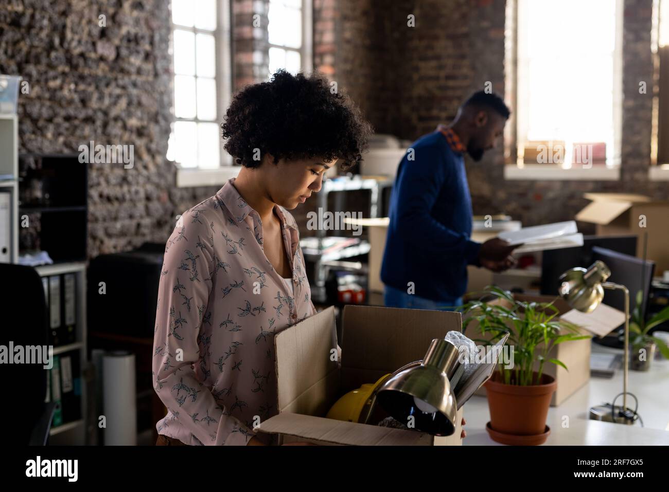 Diverse male and female colleagues unpacking boxes, moving into office ...