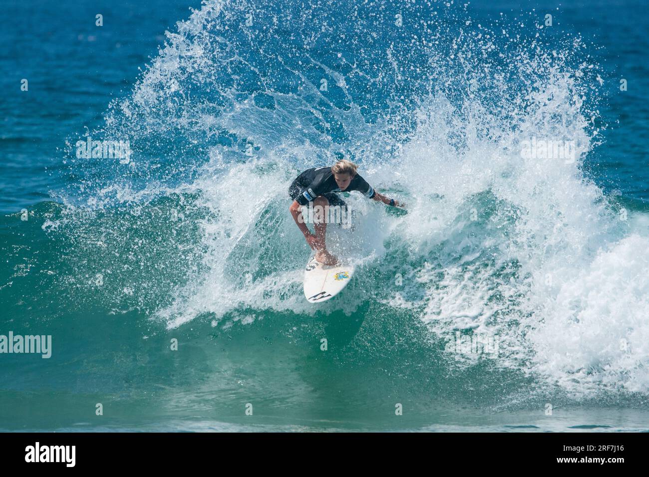 Teenage boys and girls surfing in a junior competition in Newcastle NSW ...