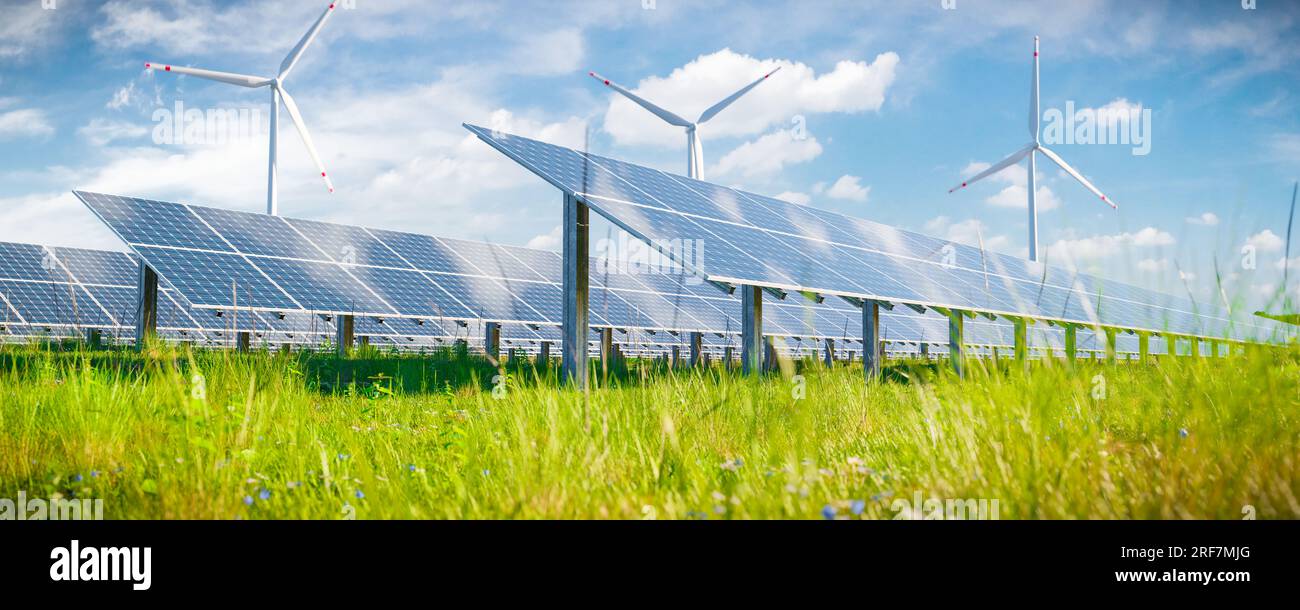 Solar farm of photovoltaic panels on a beautiful green meadow with wind ...