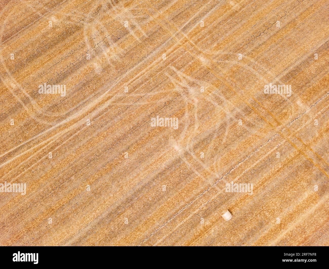 Striking tracks and patterns from a tractor on a dry agricultural field ...