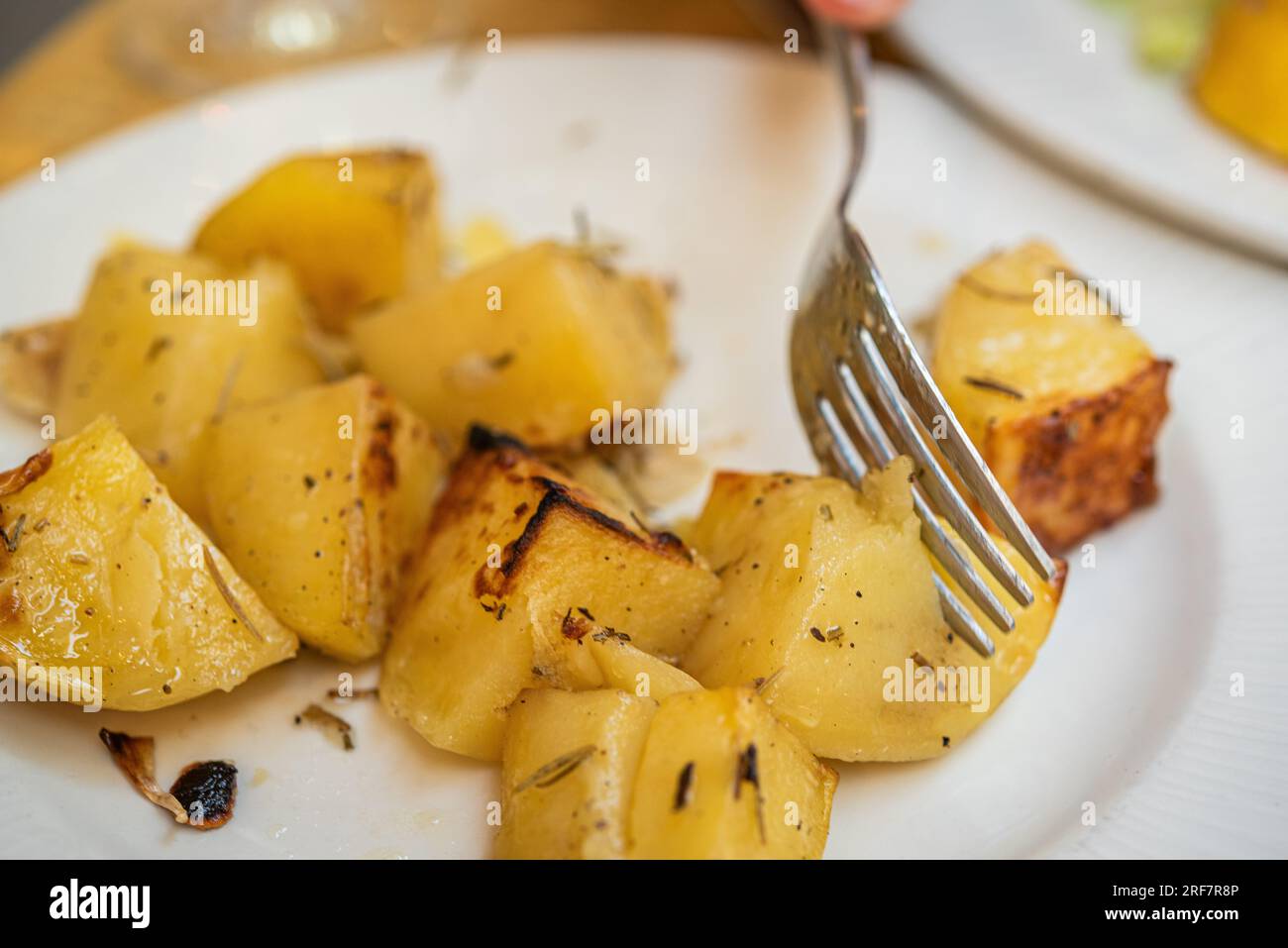 Oven roasted potatoes on a white plate in an Italian restaurant Stock ...