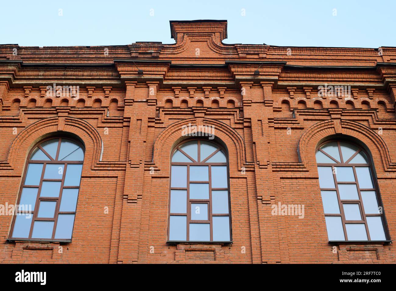 Below angle of red brick historical monument with three windows ...
