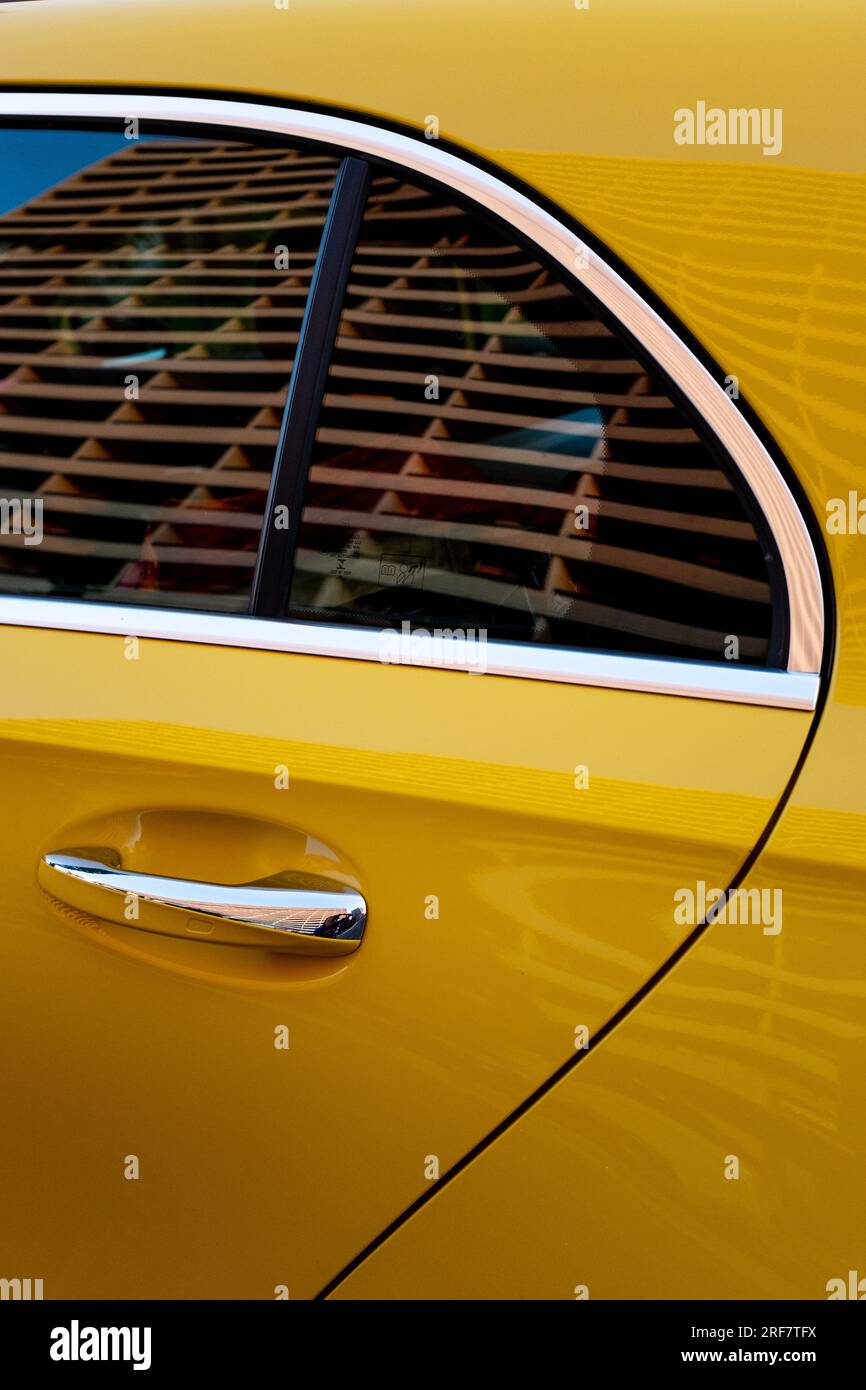 reflection in yellow car window of parked car Stock Photo - Alamy