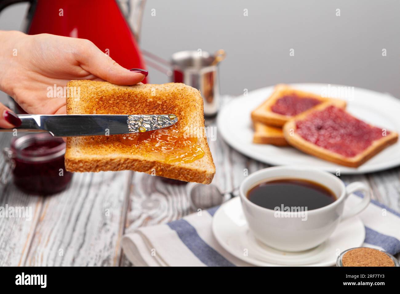 Female hands preparing toasts with fruit jam Stock Photo - Alamy