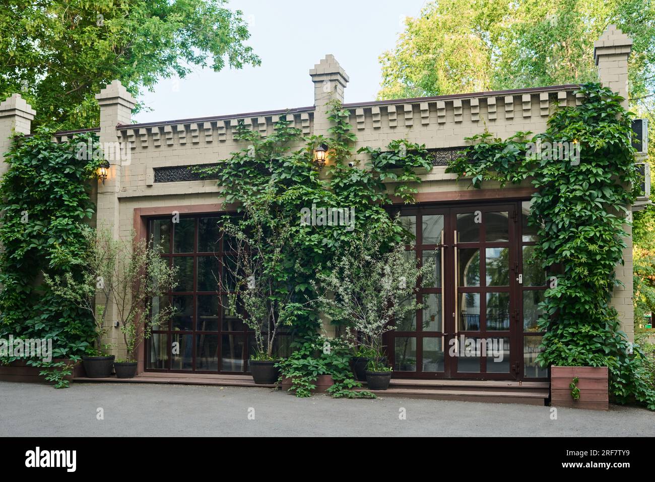 Small one storey store built up of grey brick standing in front of ...