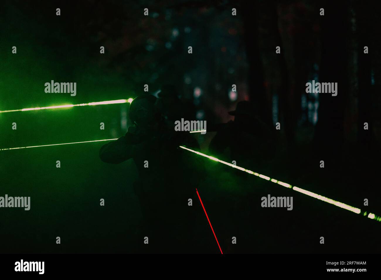 Soldiers squad in action on night mission using laser sight beam lights ...