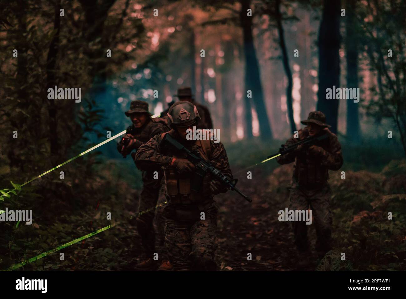 Soldiers squad in action on night mission using laser sight beam lights ...