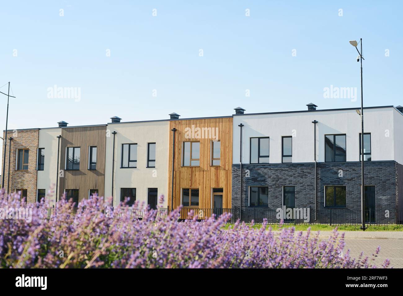 Long row of small two storey houses of neutral colors with rectangular ...