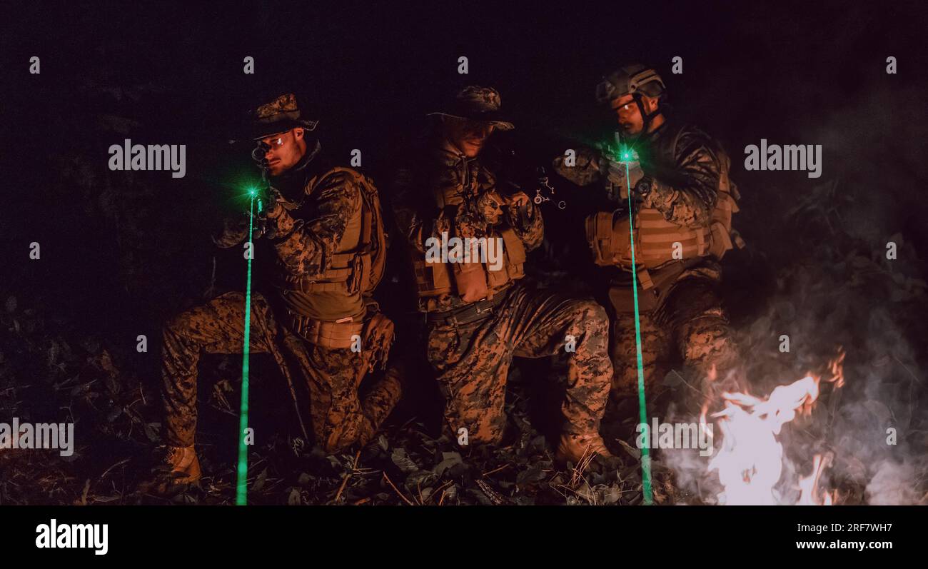 Soldiers squad in action on night mission using laser sight beam lights ...