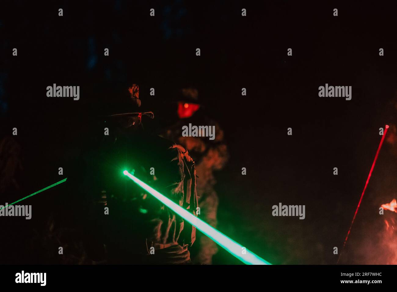 Soldiers squad in action on night mission using laser sight beam lights ...