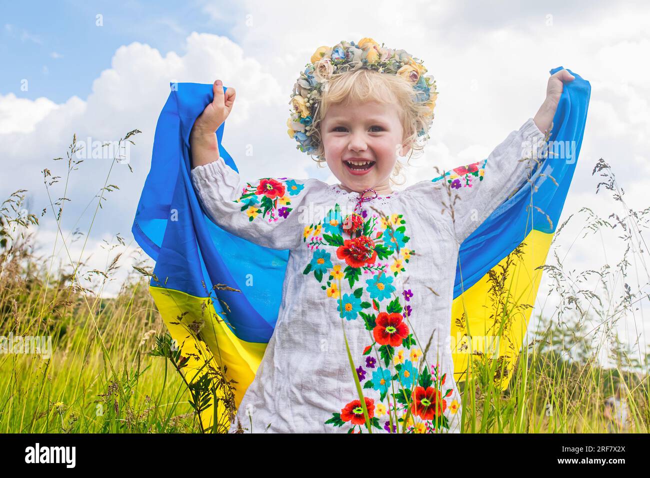 flag of Ukraine is on the shoulders of a little Ukrainian girl. Happy ...
