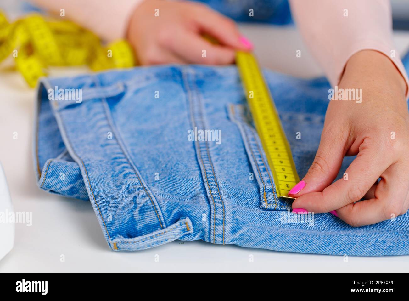 Woman tailor making measurements with measuring tape in her office ...