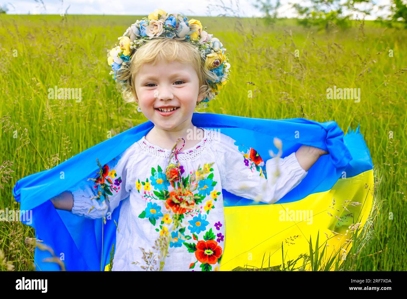 flag of Ukraine is on the shoulders of a little Ukrainian girl. Happy ...