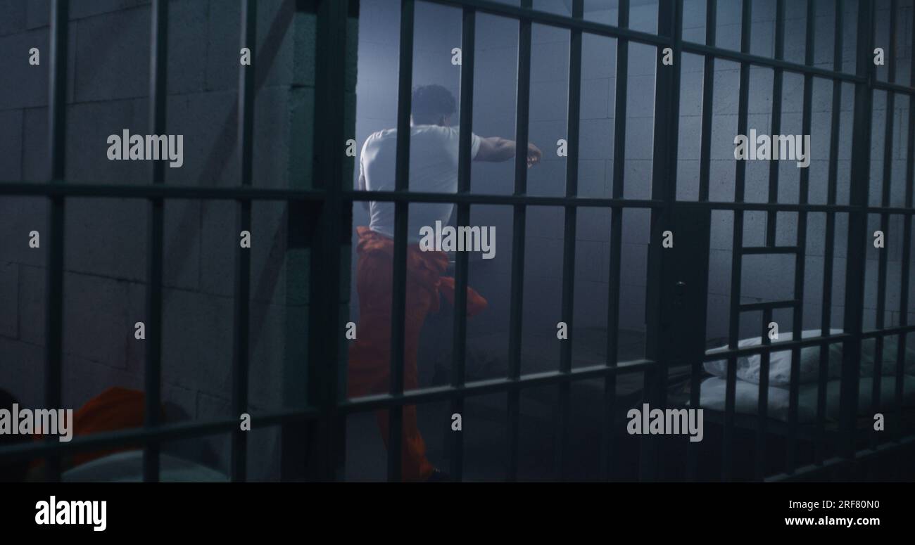 Male African American prisoner in orange uniform does shadow boxing in ...