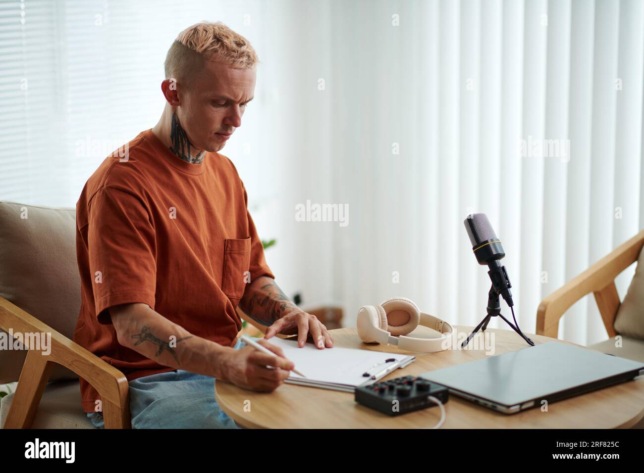 Creative man writing script before recording podcast in his studio ...