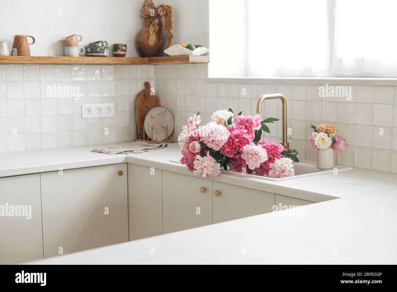 Pink peony and roses flowers in modern kitchen interior, summer floral ...