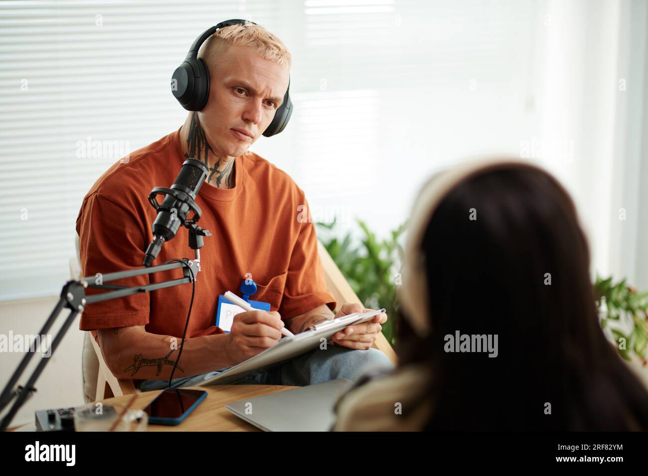 Radio host taking notes when talking to guest of talk show Stock Photo ...