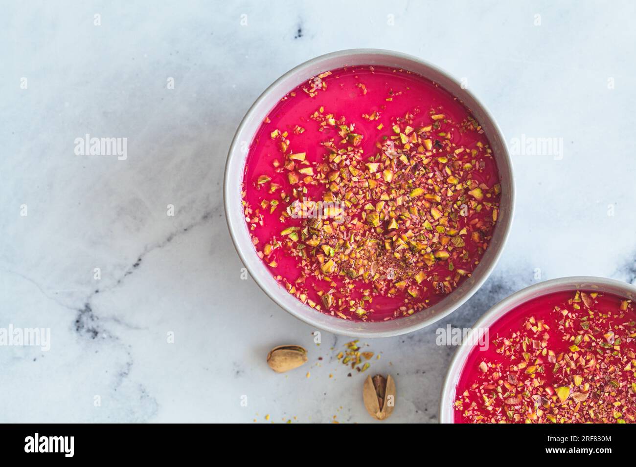 Malabi traditional Arabic dessert. Milk pudding with pink syrup and ...