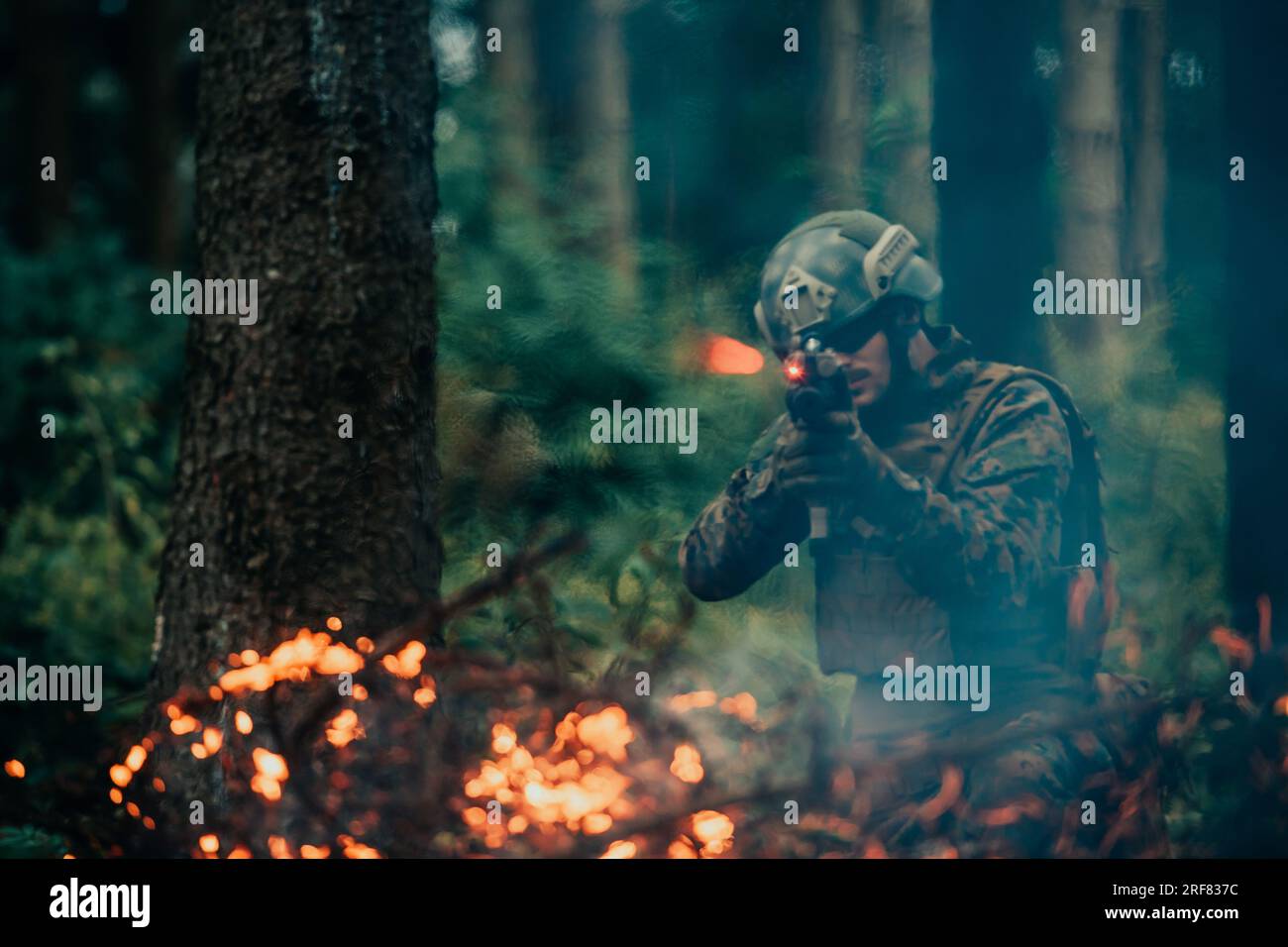 A soldier fights in a warforest area surrounded by fire Stock Photo - Alamy