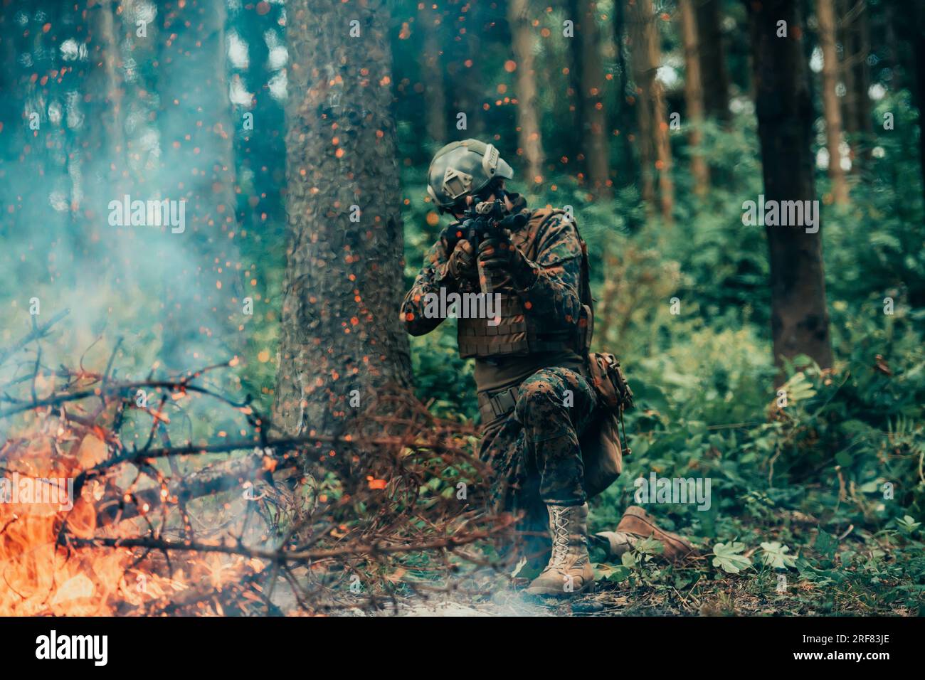 A soldier fights in a warforest area surrounded by fire Stock Photo - Alamy