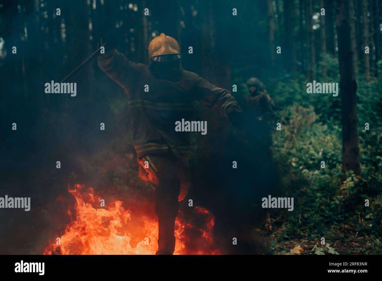 firefighter hero in action danger jumping over fire flame to rescue and ...