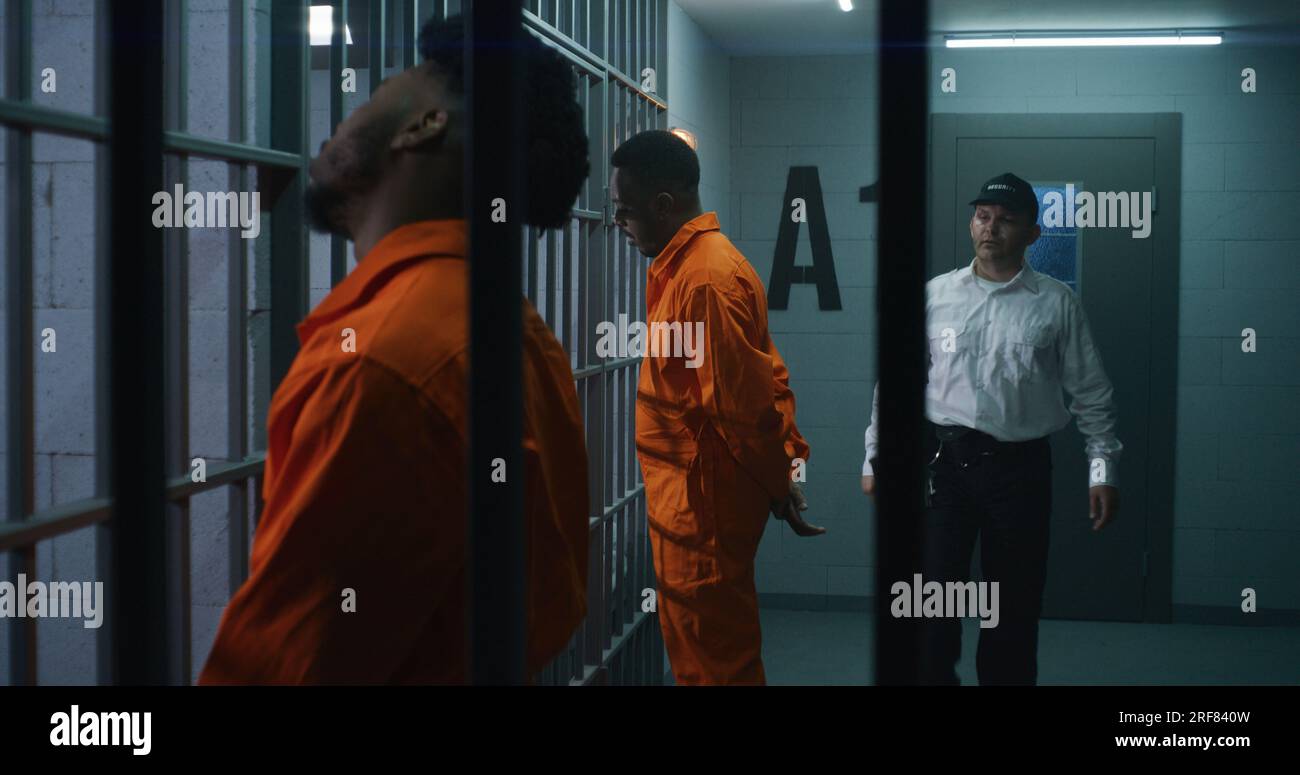 Prison employee with police baton walks at jail corridor and bullies ...