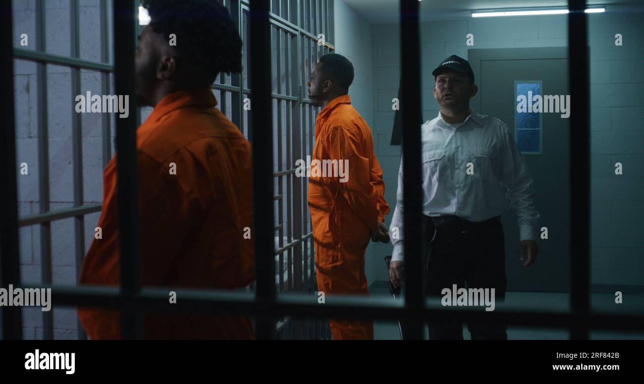 Prison employee with police baton walks at jail corridor and bullies ...