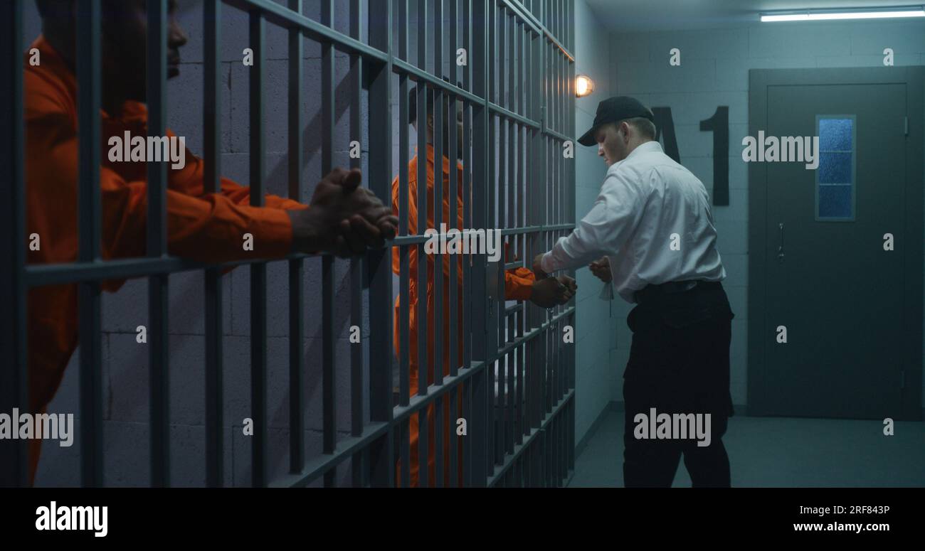Warden brings new prisoner in jail cell and takes off his handcuffs ...