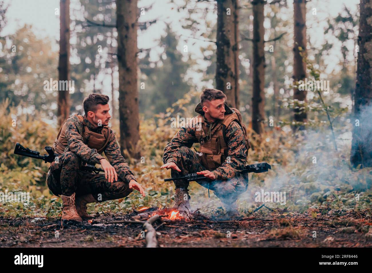 Two exhausted soldiers sitting by the fire after a weary and heavy war ...