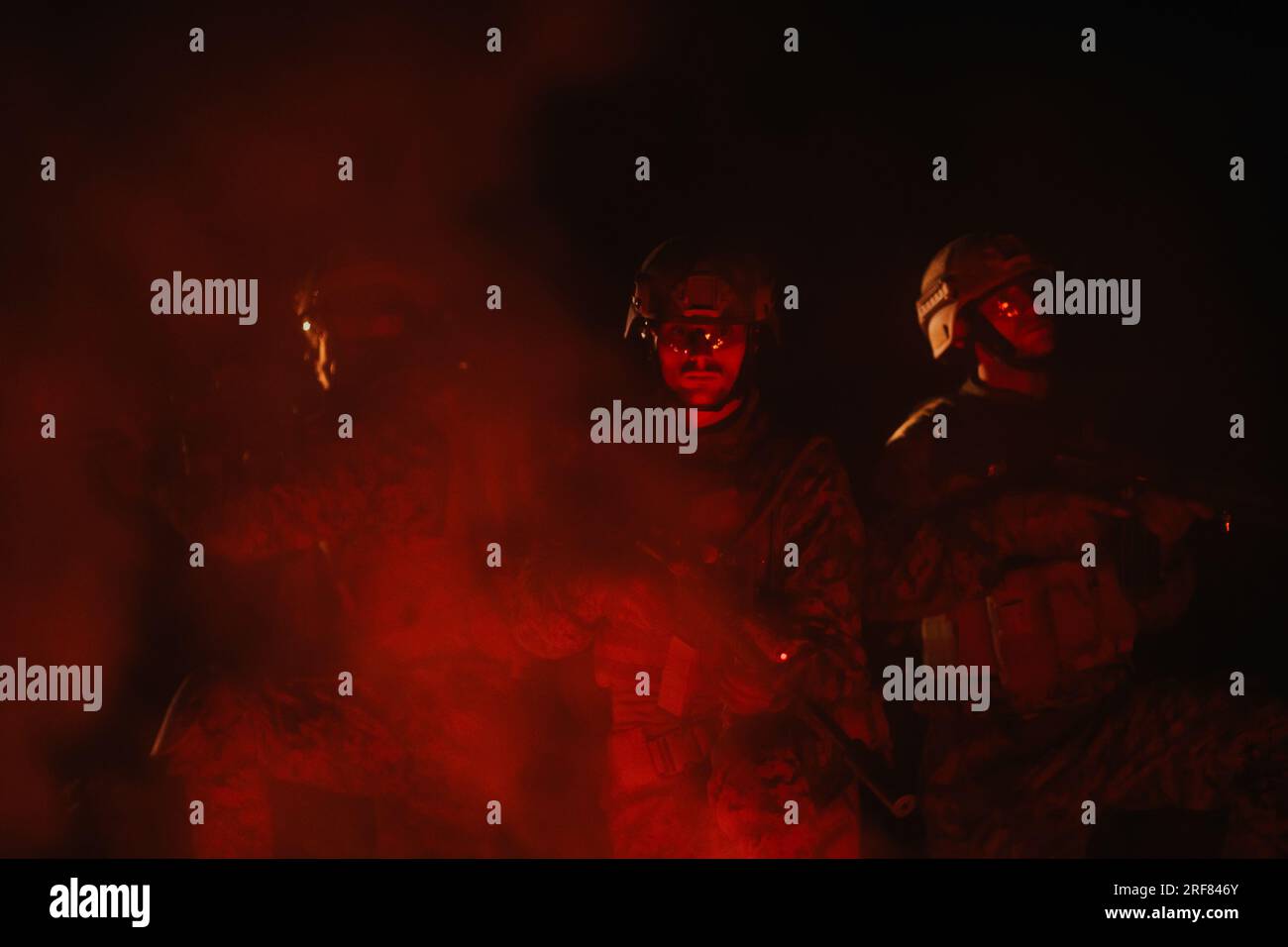 Soldiers squad in action on night mission using laser sight beam lights ...