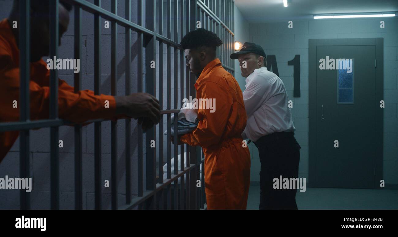 Warden brings new prisoner in jail cell and takes off his handcuffs ...