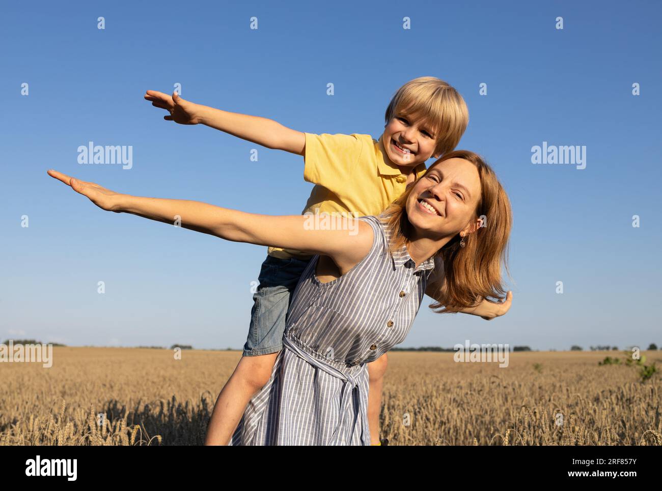 mom and son 6-7 years old, play together in nature. woman holds child ...