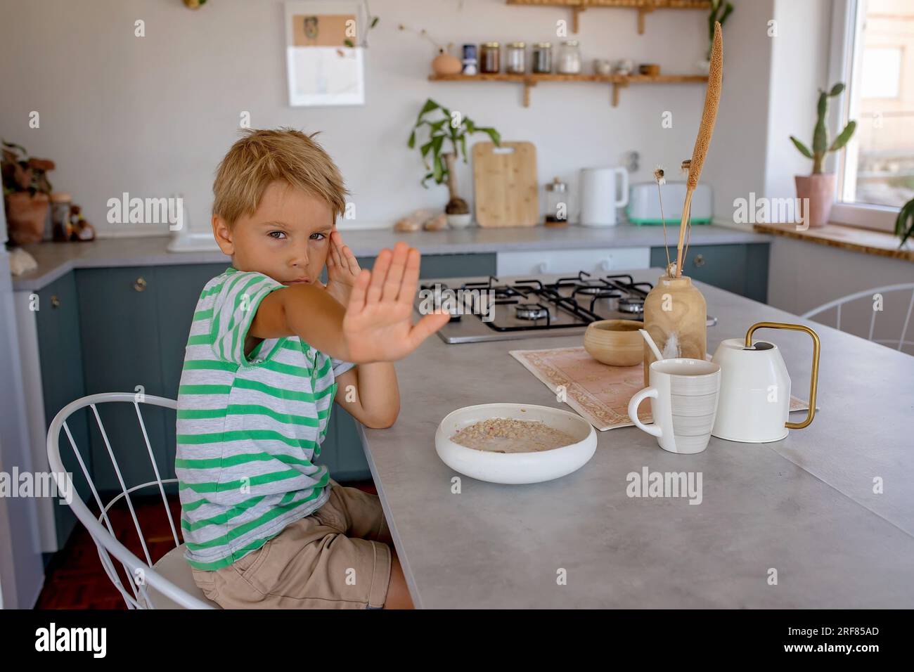 Beautiful blond child, boy, refusing to eat cereal for breakfast at ...