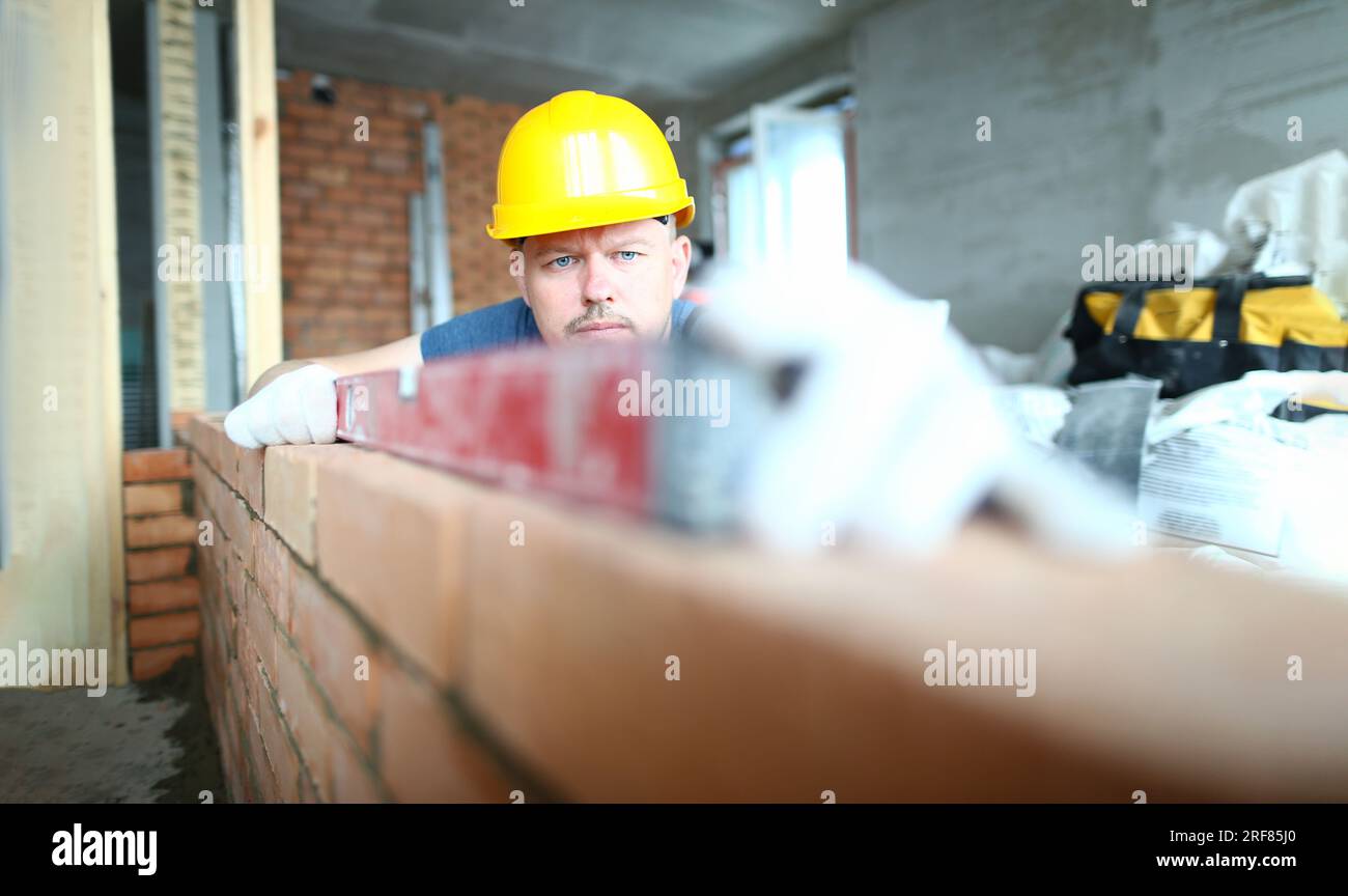 Builder measures level of brickwork with device Stock Photo - Alamy