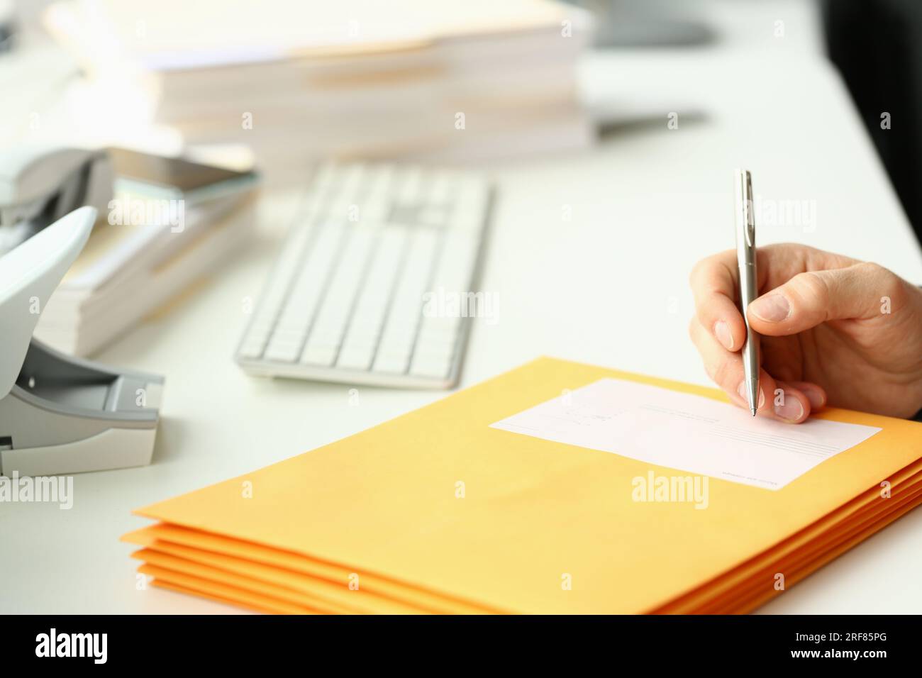 Person fill in address on yellow envelope of postal correspondence for ...