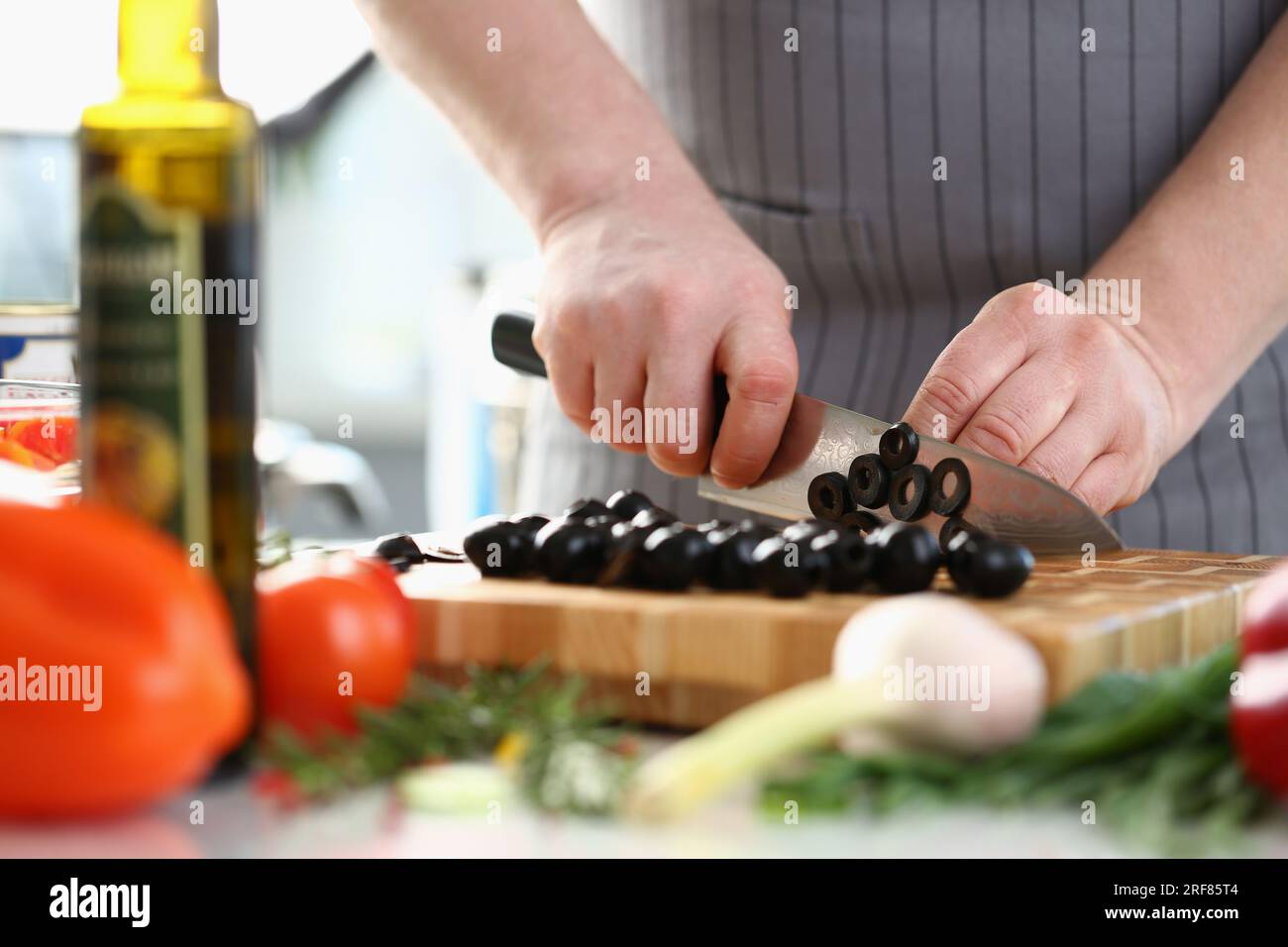 Process of preparing vitamin greek salad and cutting olives Stock Photo ...