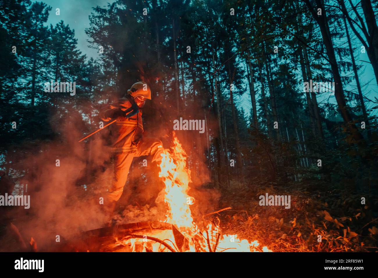 firefighter hero in action danger jumping over fire flame to rescue and ...