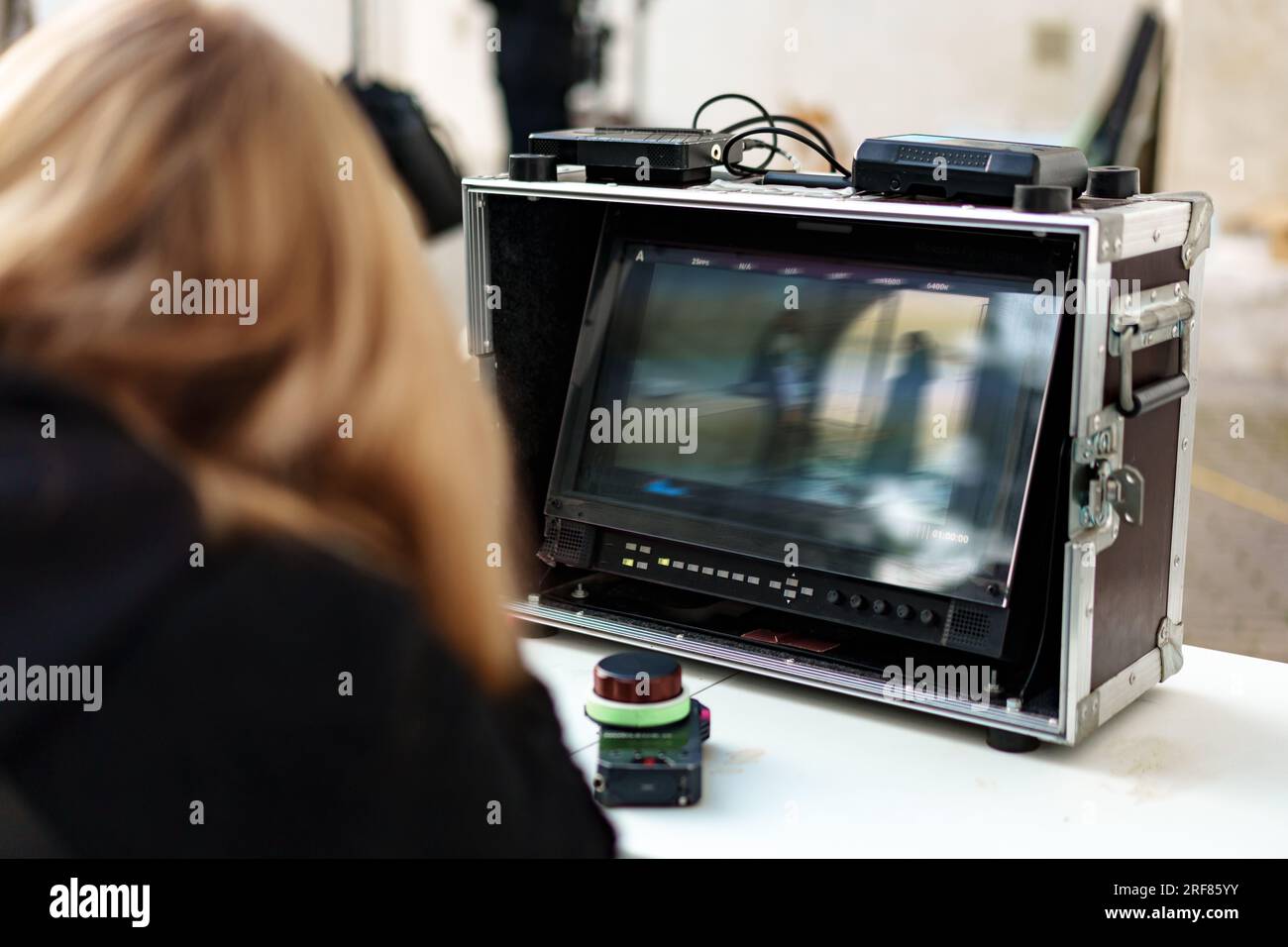 Female director in chair looking at display watching shootings on set ...