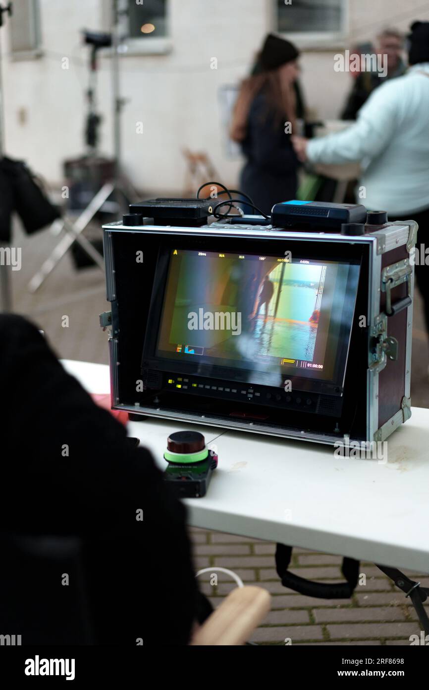 Director in chair looking at display watching shootings on set back ...