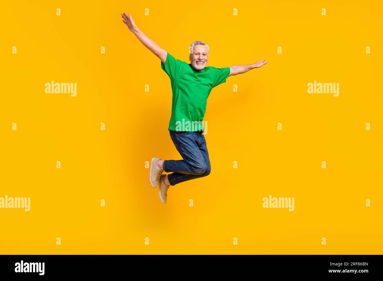 Full size portrait of active cheerful aged person jumping raise arms ...