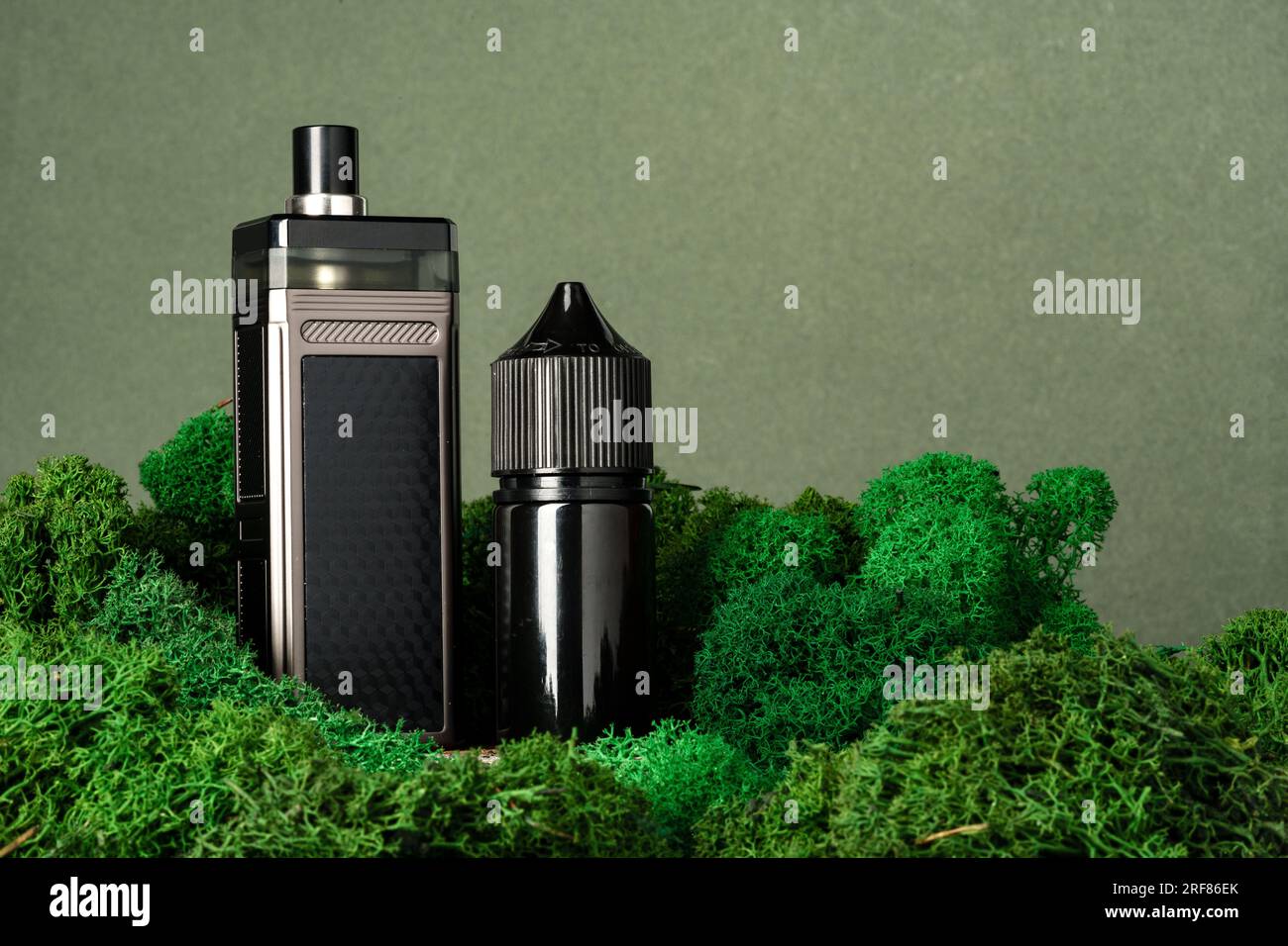 Vape smoking liquid bottles on moss background Stock Photo - Alamy