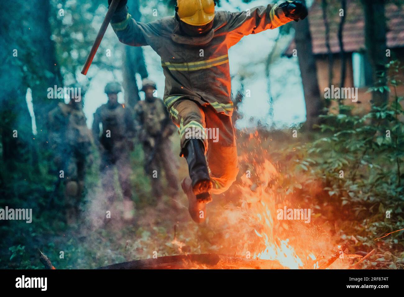 firefighter hero in action danger jumping over fire flame to rescue and ...